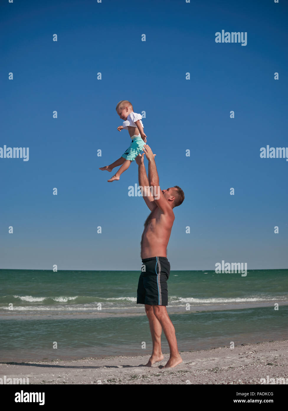 Dad and Baby playing on seaside in summertime. Happy family and happy ...