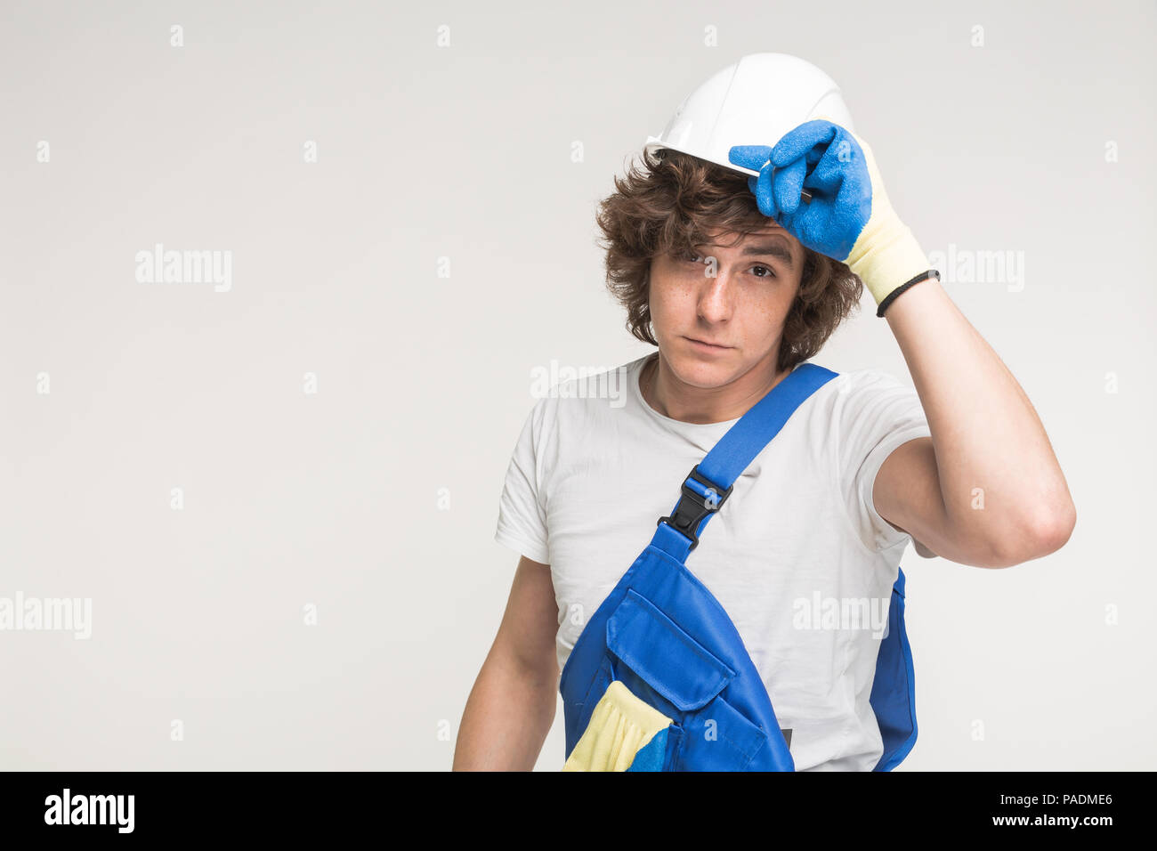 Builder man with tired face wipes forehead. Hard work concept ...