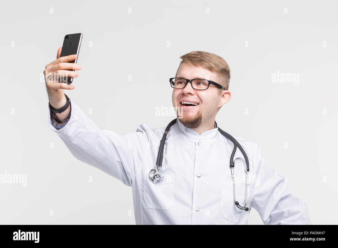Happy male doctor making selfie in studio Stock Photo - Alamy
