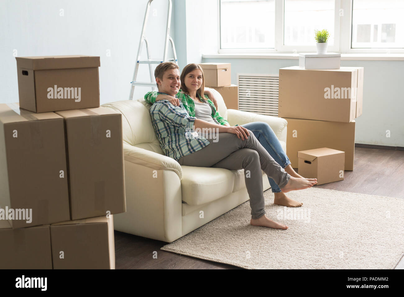 Happy young couple posing on sofa between boxes in a new house Stock ...