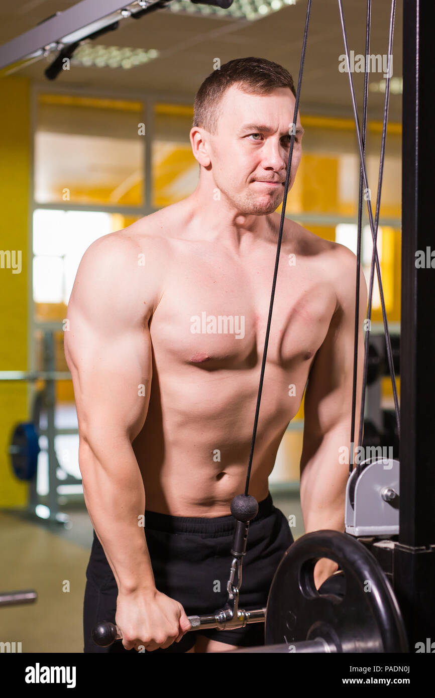 Strong muscular bodybuilder doing exercise in the gym. Fitness training ...