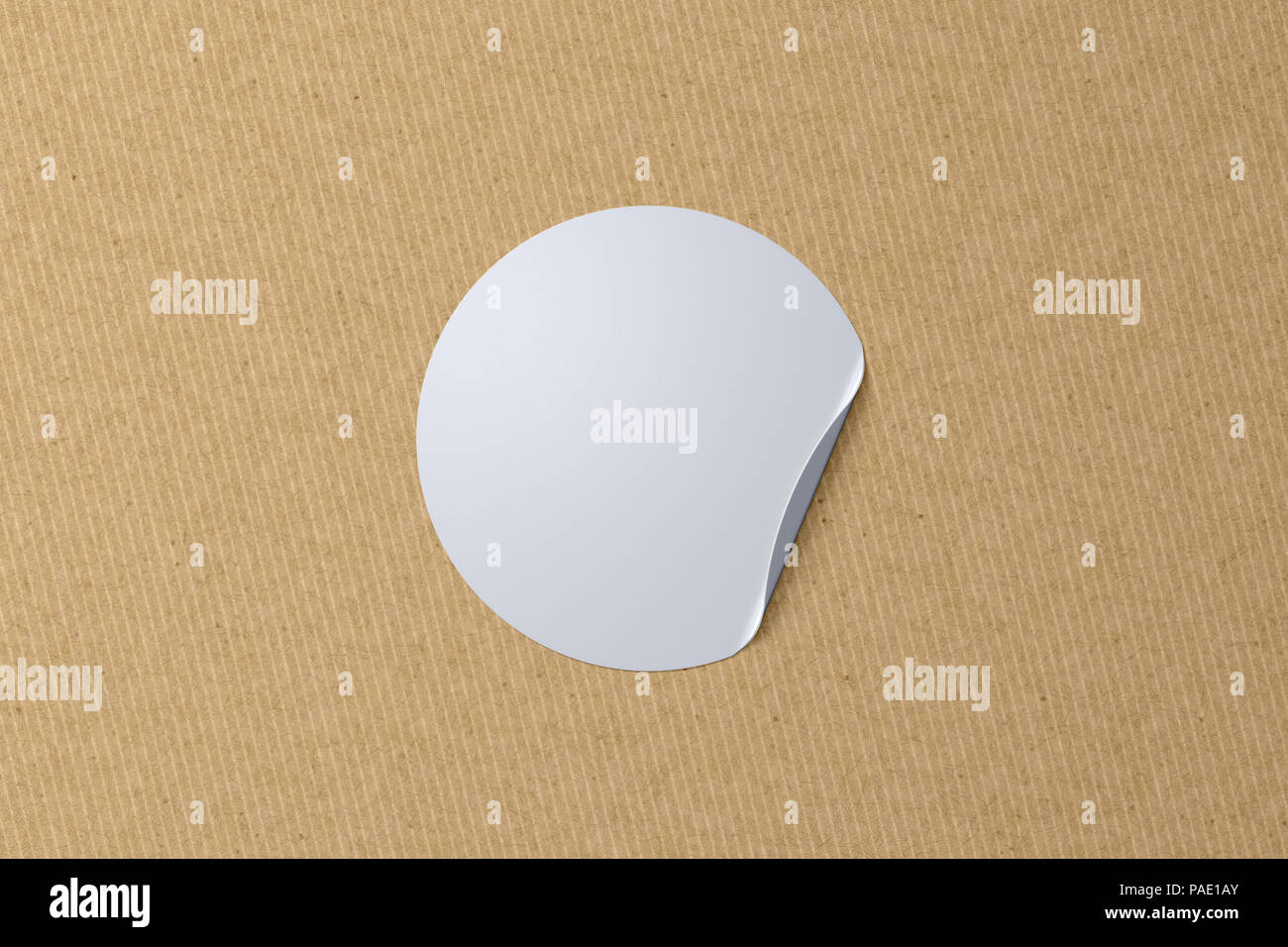 Blank white sticker with bent edge on cardboard background. 3d ...