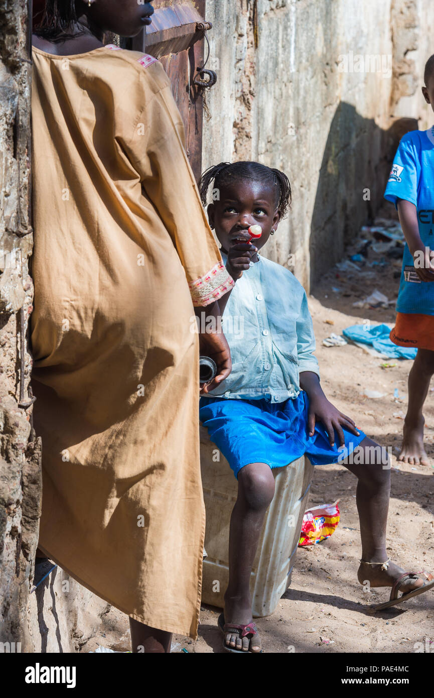 BANJUL, GAMBIA - MAR 14, 2013: Unidentified Gambian girl eats a chupa ...