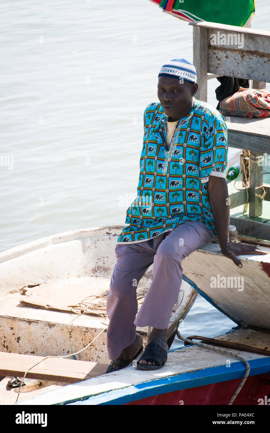 BANJUL, GAMBIA - MAR 14, 2013: Unidentified Gambian man stays on a pear ...