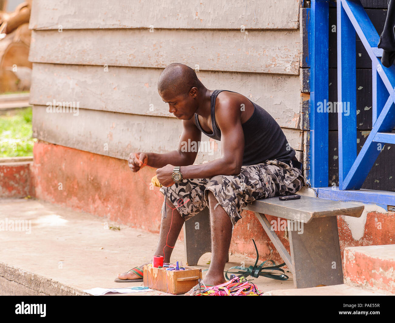 ACCRA, GHANA - MARCH 4, 2012: Unidentified Ghanaian man makes cables in ...