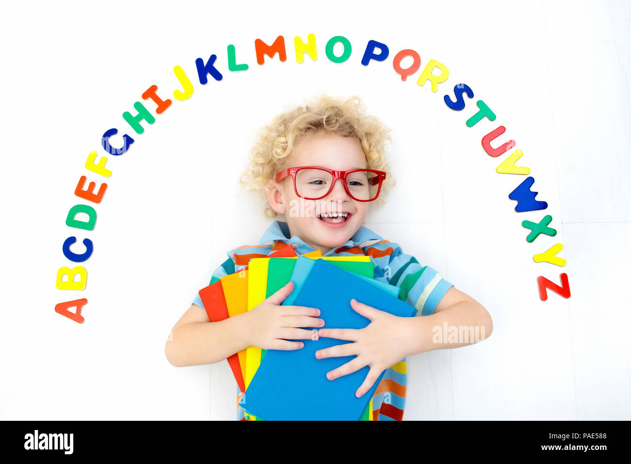 Happy preschool child learning to read and write playing with colorful ...