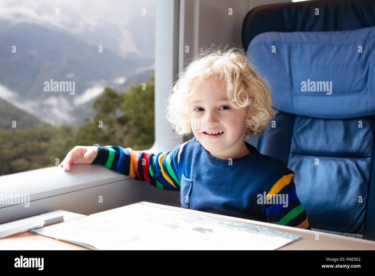 Child traveling by train. Little kid in a high speed express train on ...