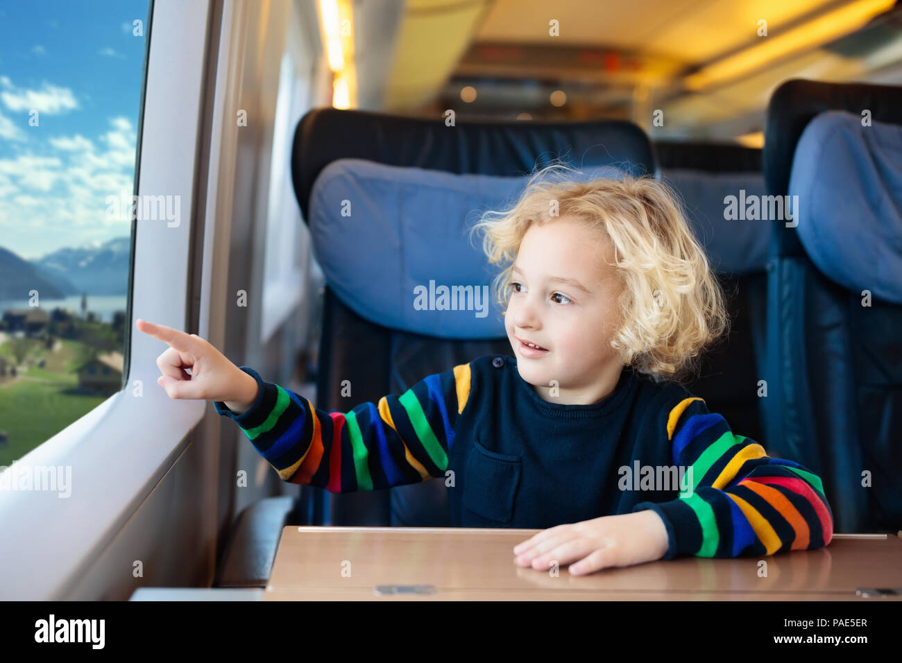 Child traveling by train. Little kid in a high speed express train on ...