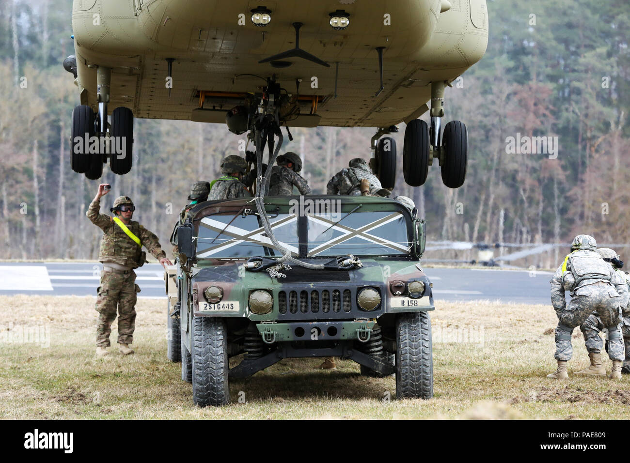 Soldiers from the 44th Expeditionary Signal Battalion, 2nd Signal Brigade attach a Humvee to a ...