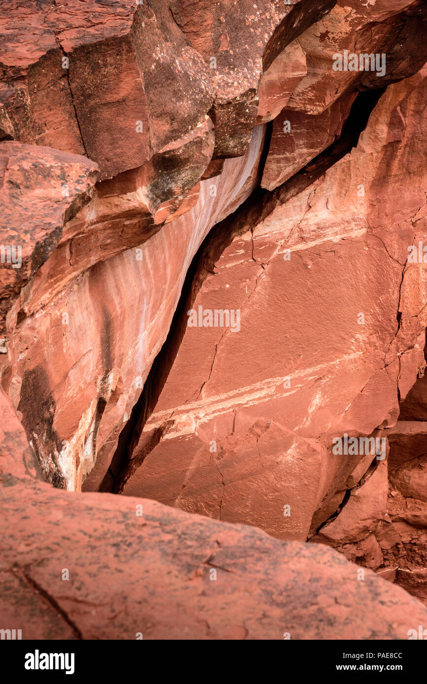 A large rock cracks off from the stone wall and is ready to fall to the ...