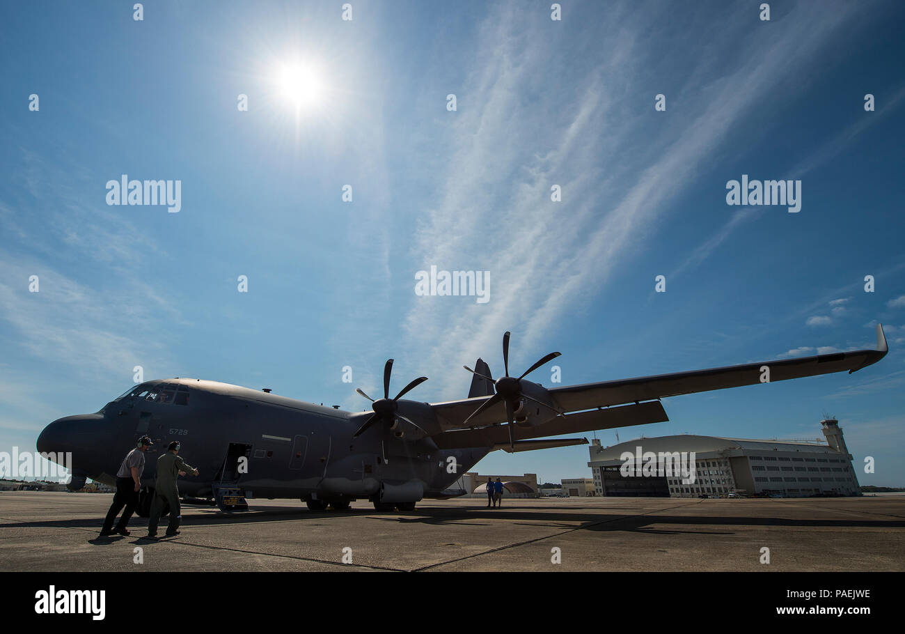 A maintainer and loadmaster complete preflight checks on a modified MC ...