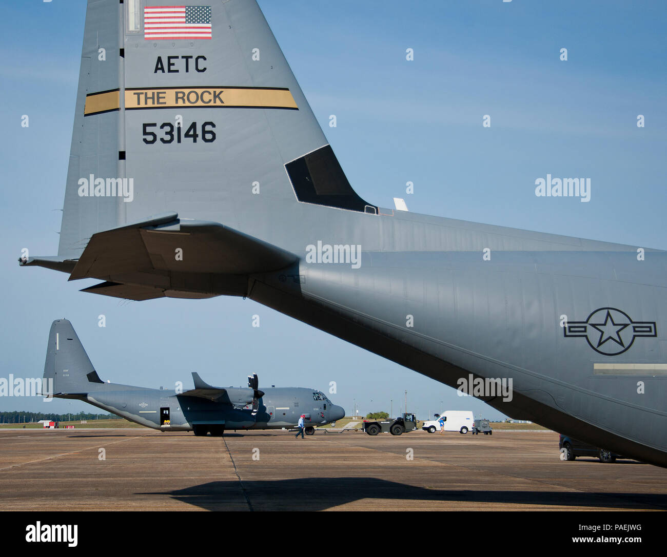 A modified MC-130J is pulled to its parking spot beside another C-130 ...