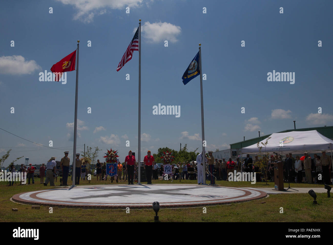 Service members and veterans conduct the raising of the Memorial Marker ...