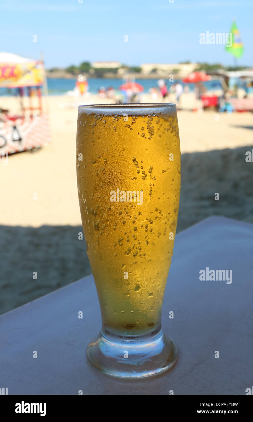 Front view of a glass of cold draft beer at sunny Copacabana beach in ...