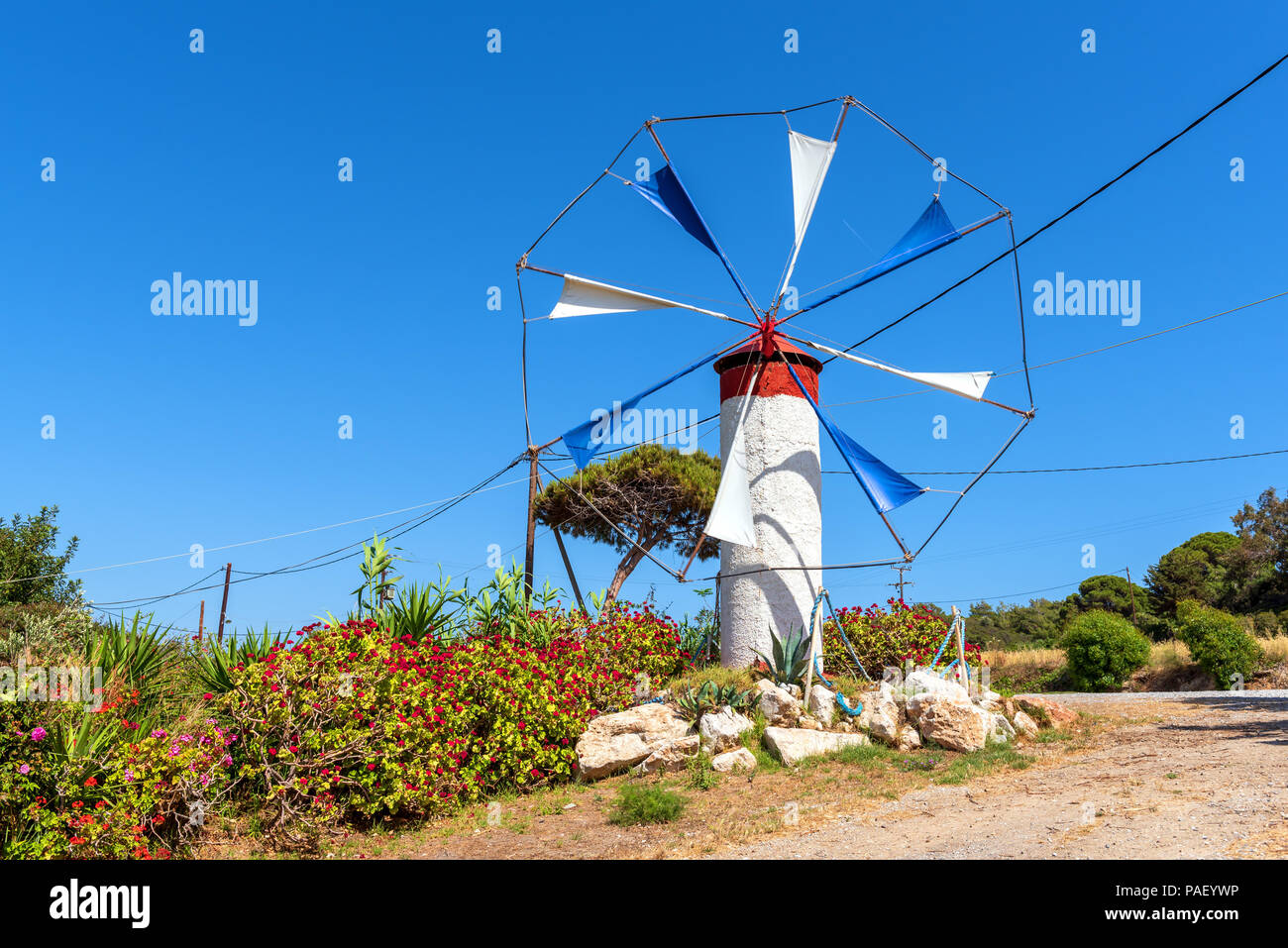 White Greek windmill against blue sky on the west coast of the island ...
