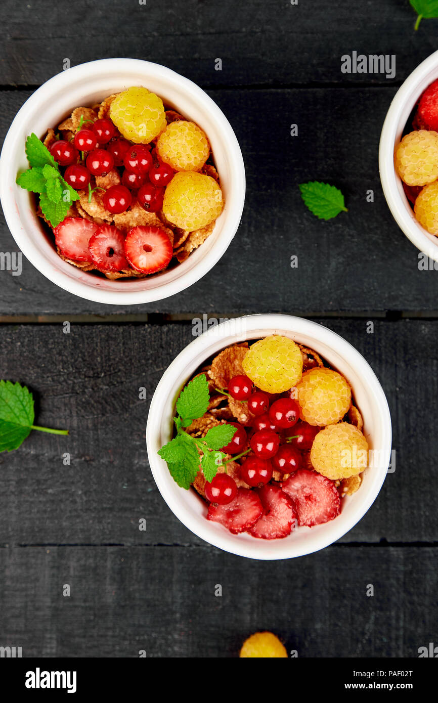 Healthy breakfast on white bowls. Fresh granola, muesli or cereal with ...