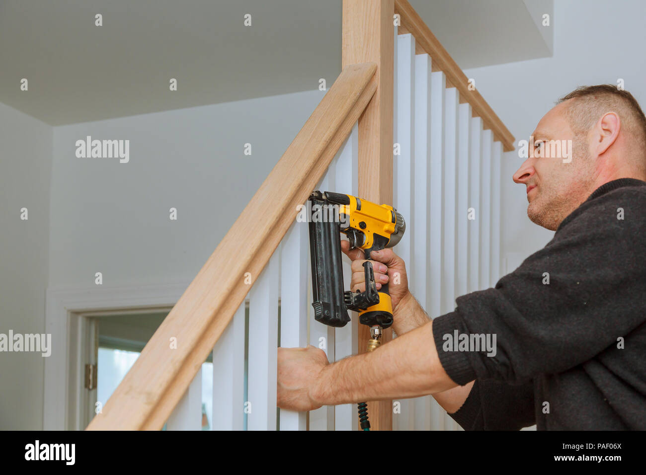 How to Install a nailing the railing for stairs with an air gun Stock ...