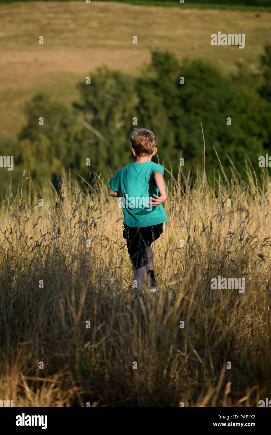 Child running through Long Grass Stock Photo - Alamy