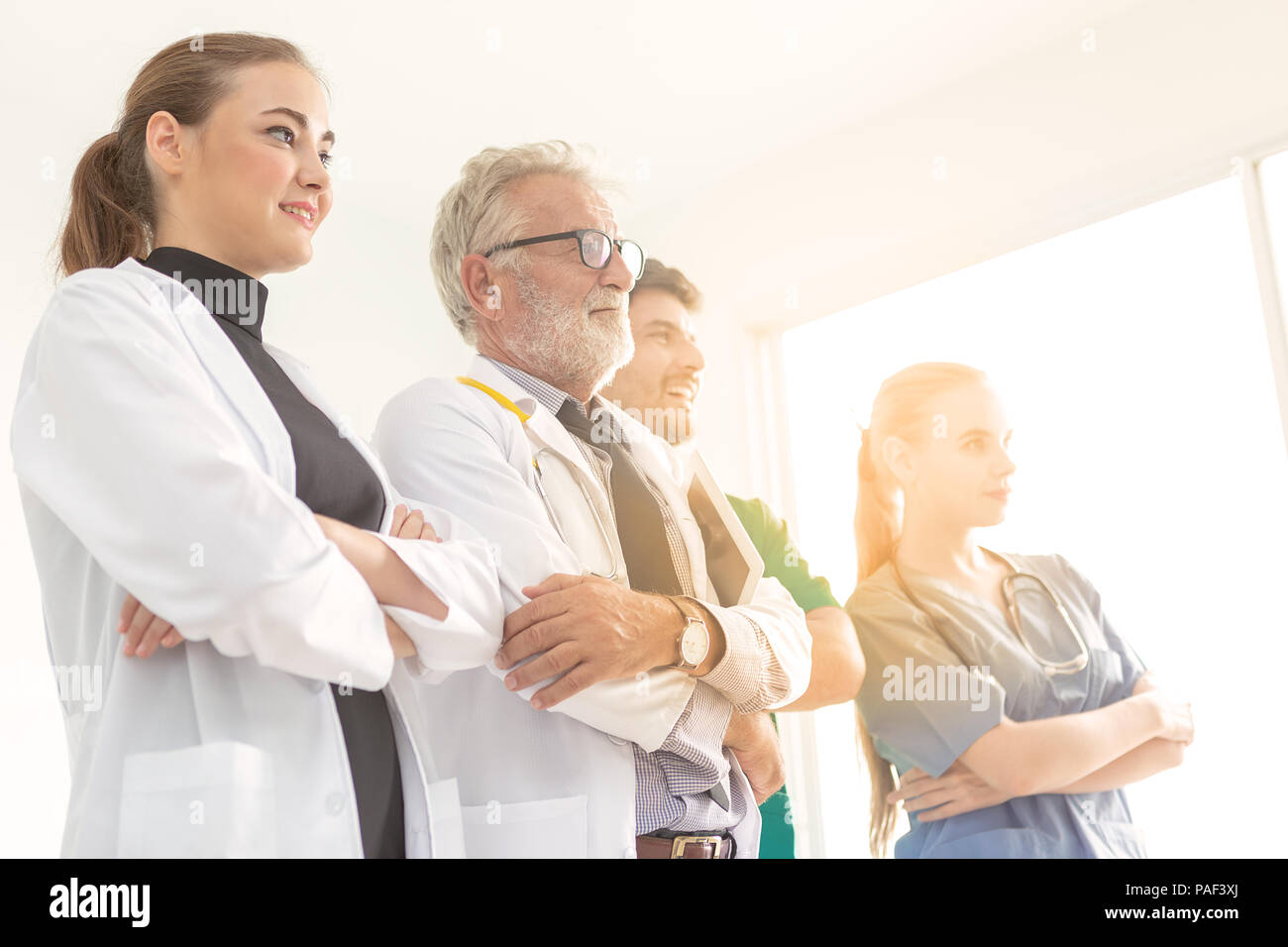 A group of doctors are using a digital tablet for discussing diagnosis ...