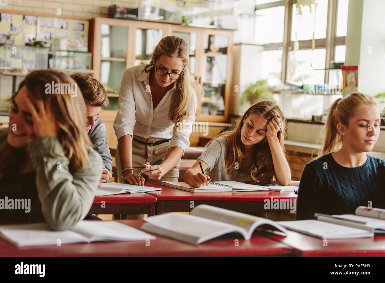 Group of university students attending lecture on campus with teacher ...