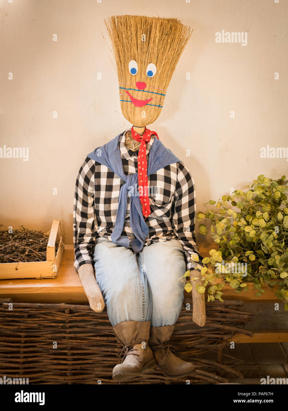 Big puppet made of a broom sitting on a table, wearing clothes Stock ...