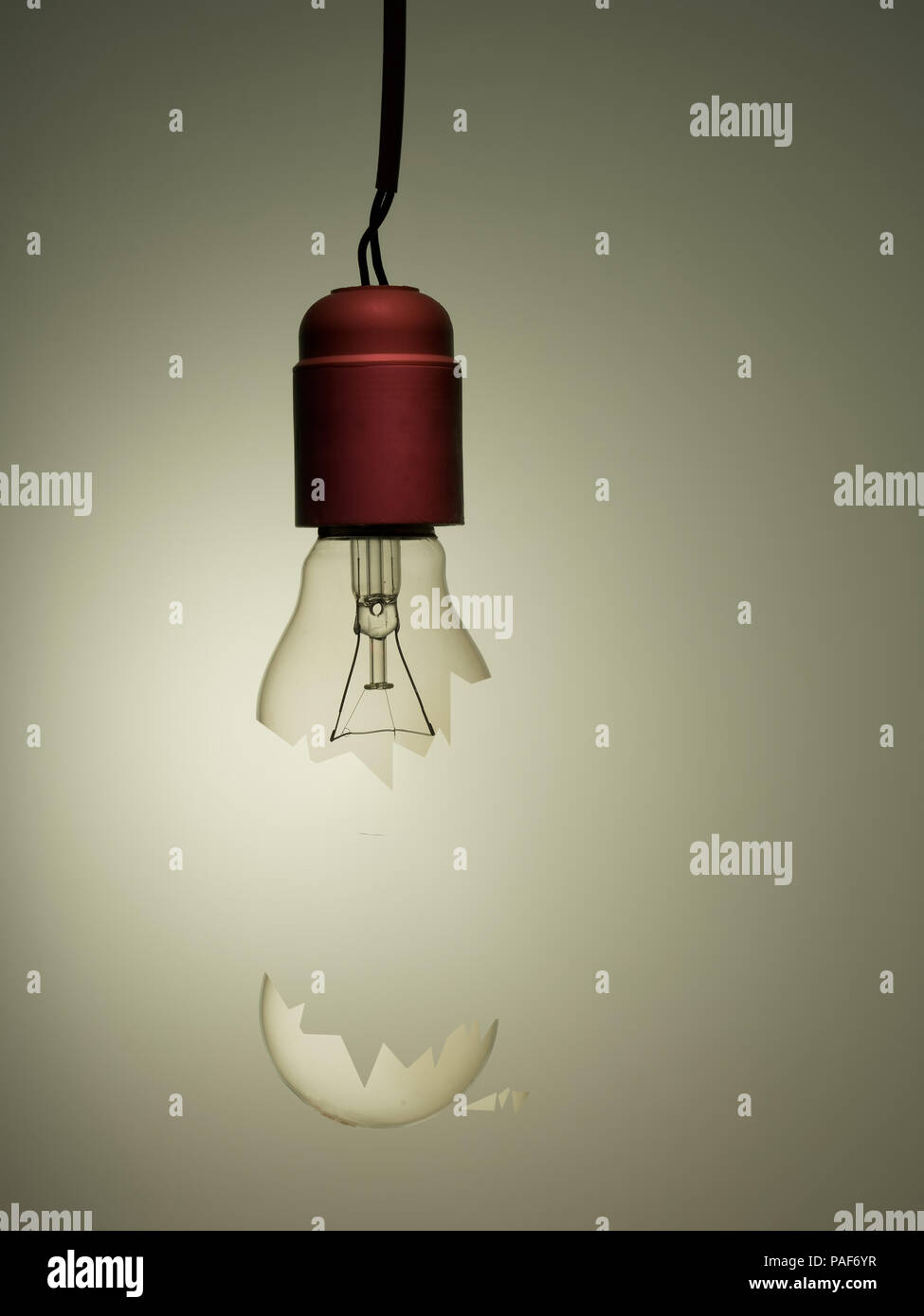 Old style incandescent broken light bulb, hanging. Concept, metaphor ...