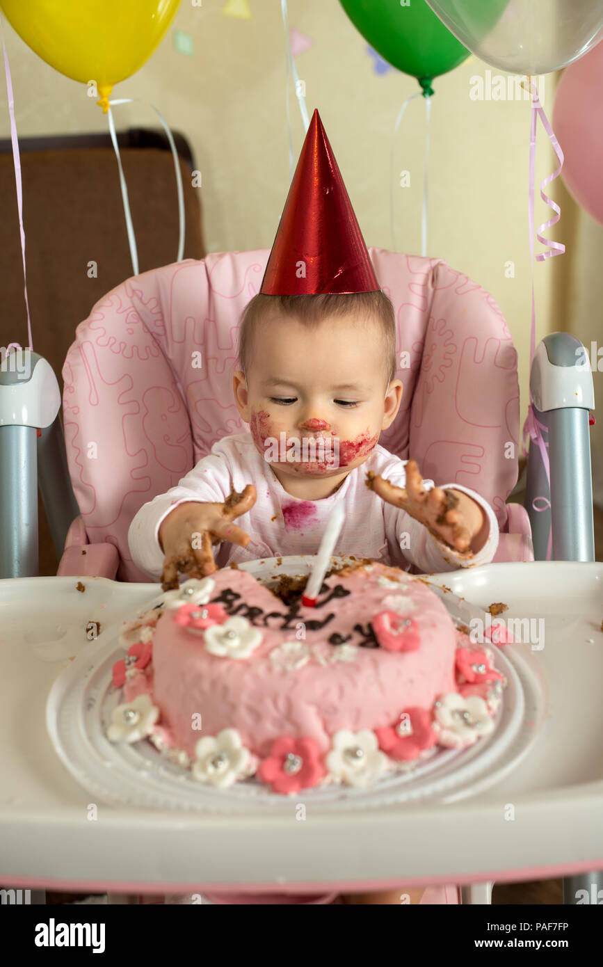 one-year-old little girl solemnize birthday, eating cake, vertical ...