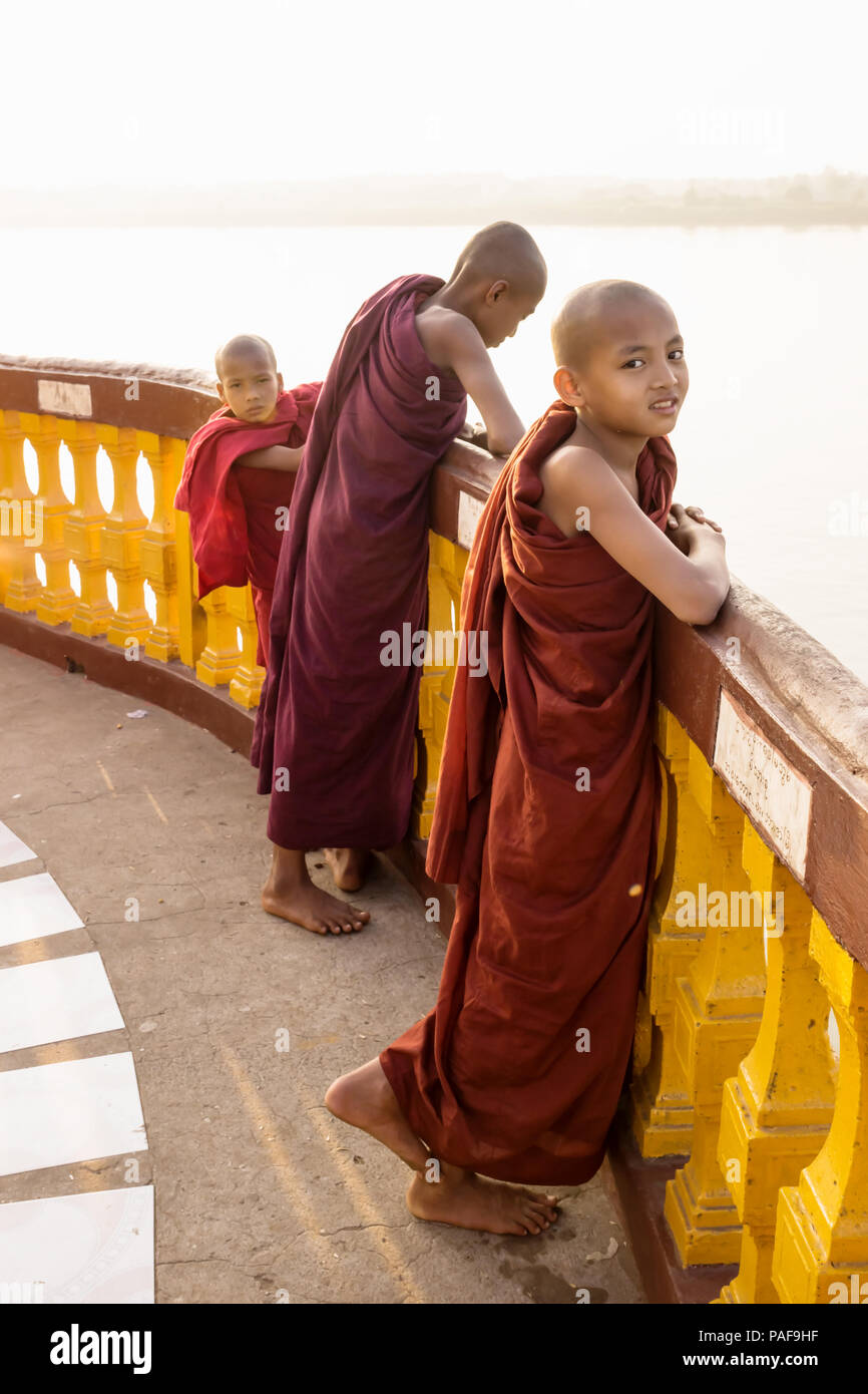 Three monks standing at the pagoda along the river in Hpa-an vertical ...