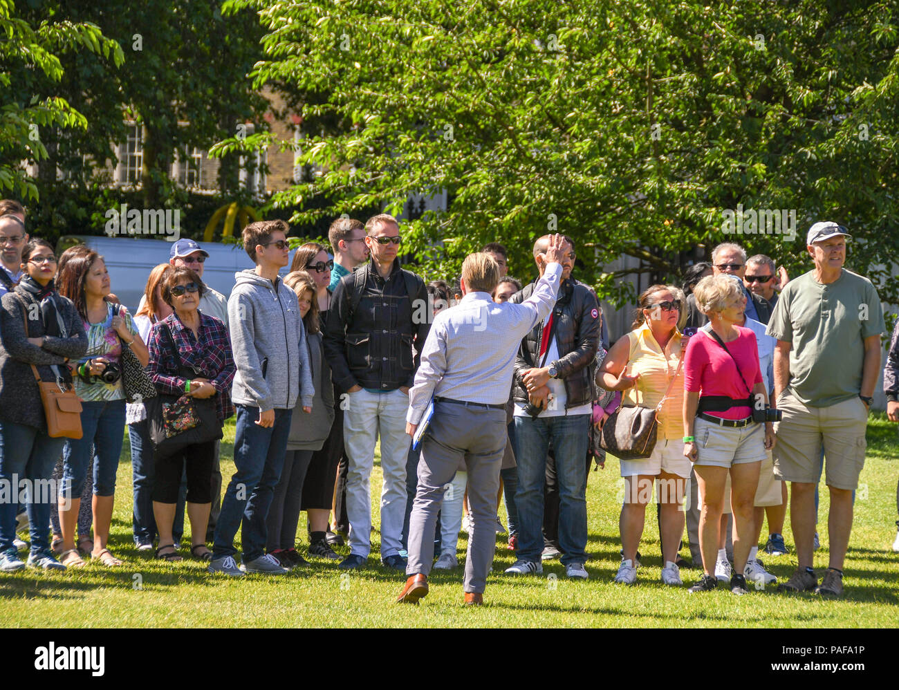 Tour guide explaining the history of the area to a group of tourists ...