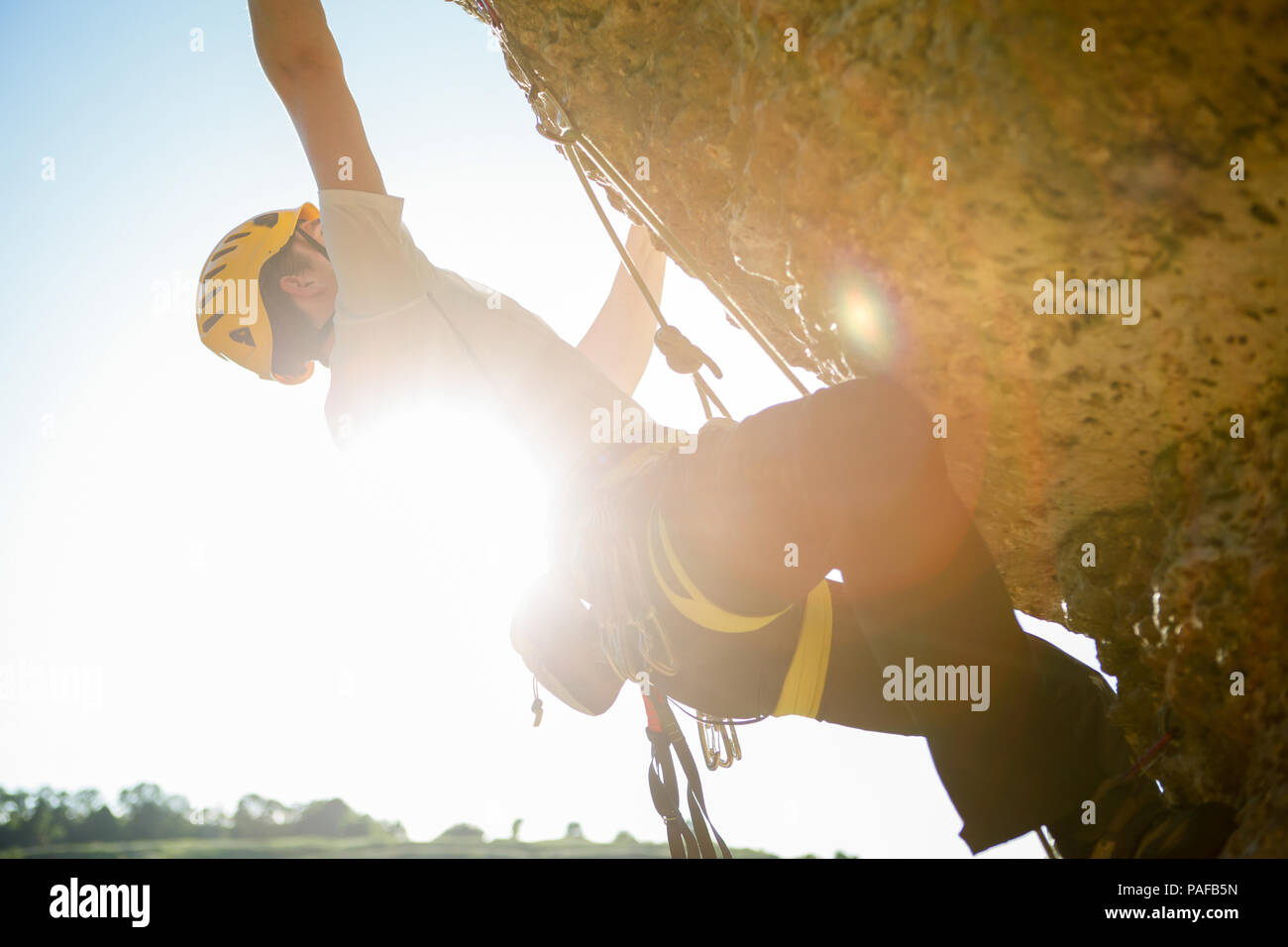 Image of tourist man in helmet clambering up Stock Photo - Alamy