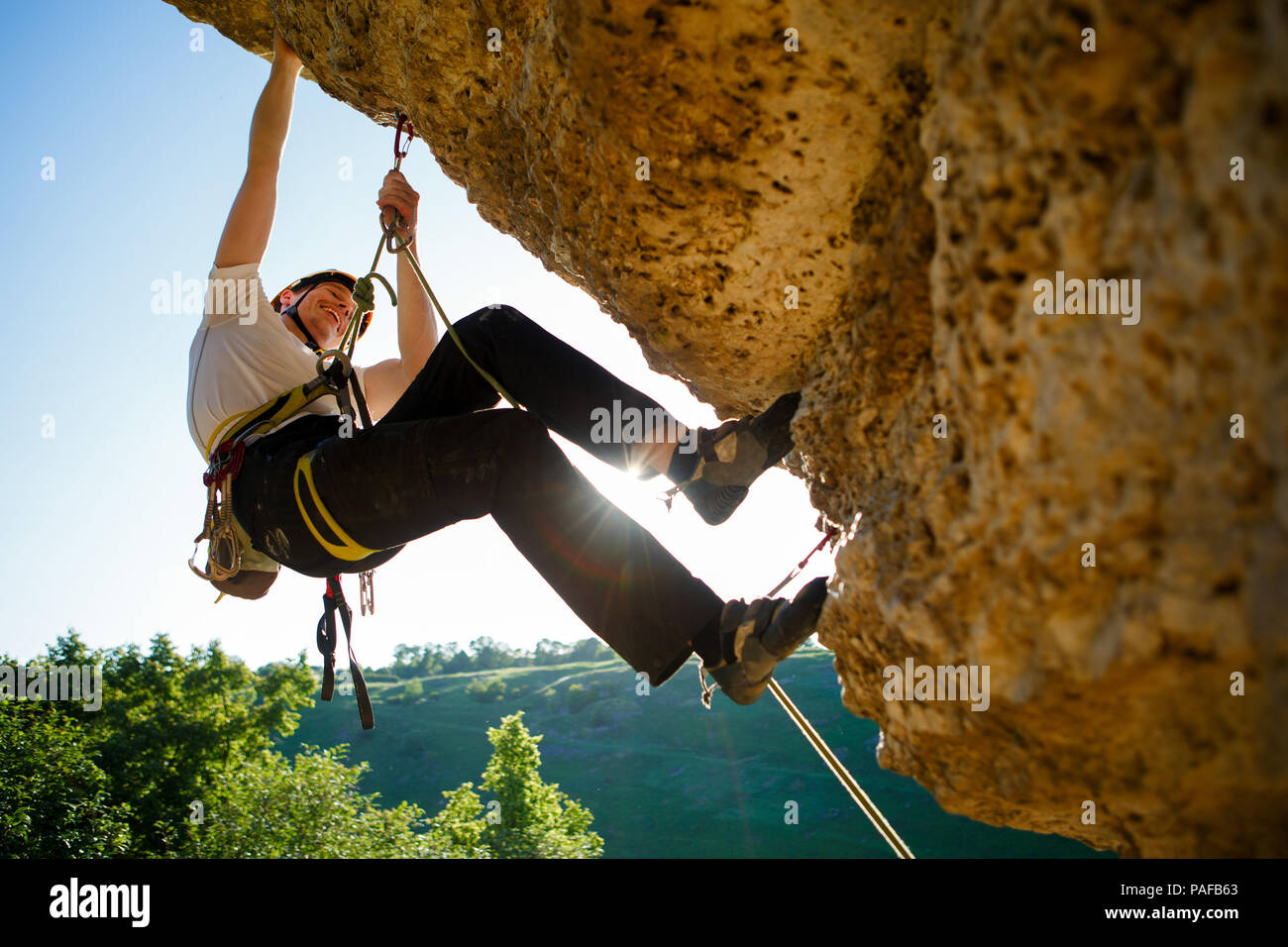 Image of tourist man in helmet clambering up Stock Photo - Alamy