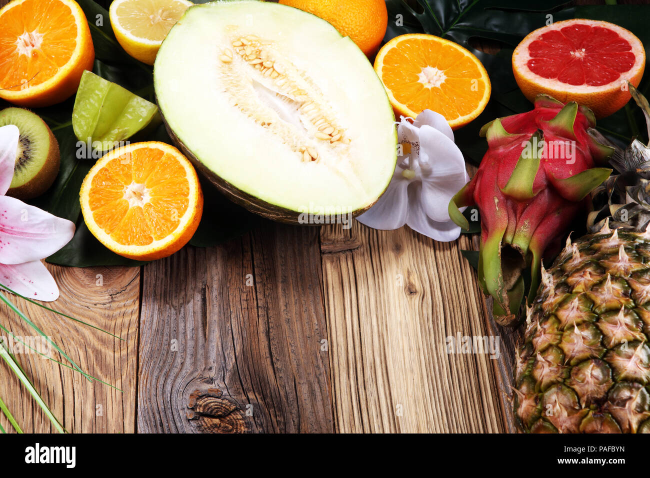 Tropical fruit. Assortment of tropical fruits with leaves of palm trees ...
