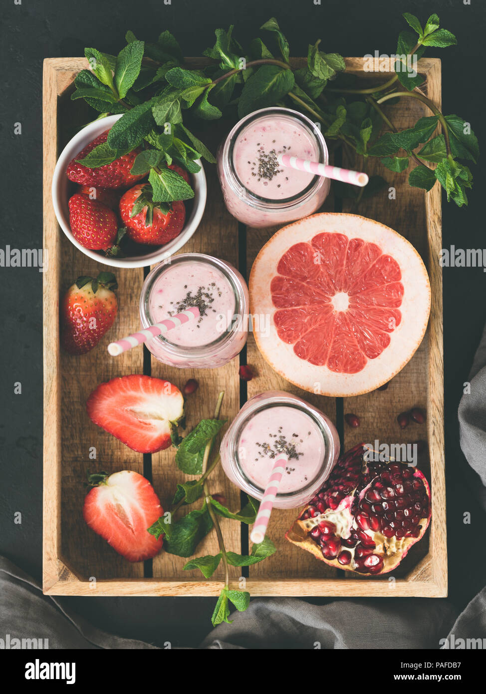 Fruit and berry smoothies on wooden tray, top view, toned image ...