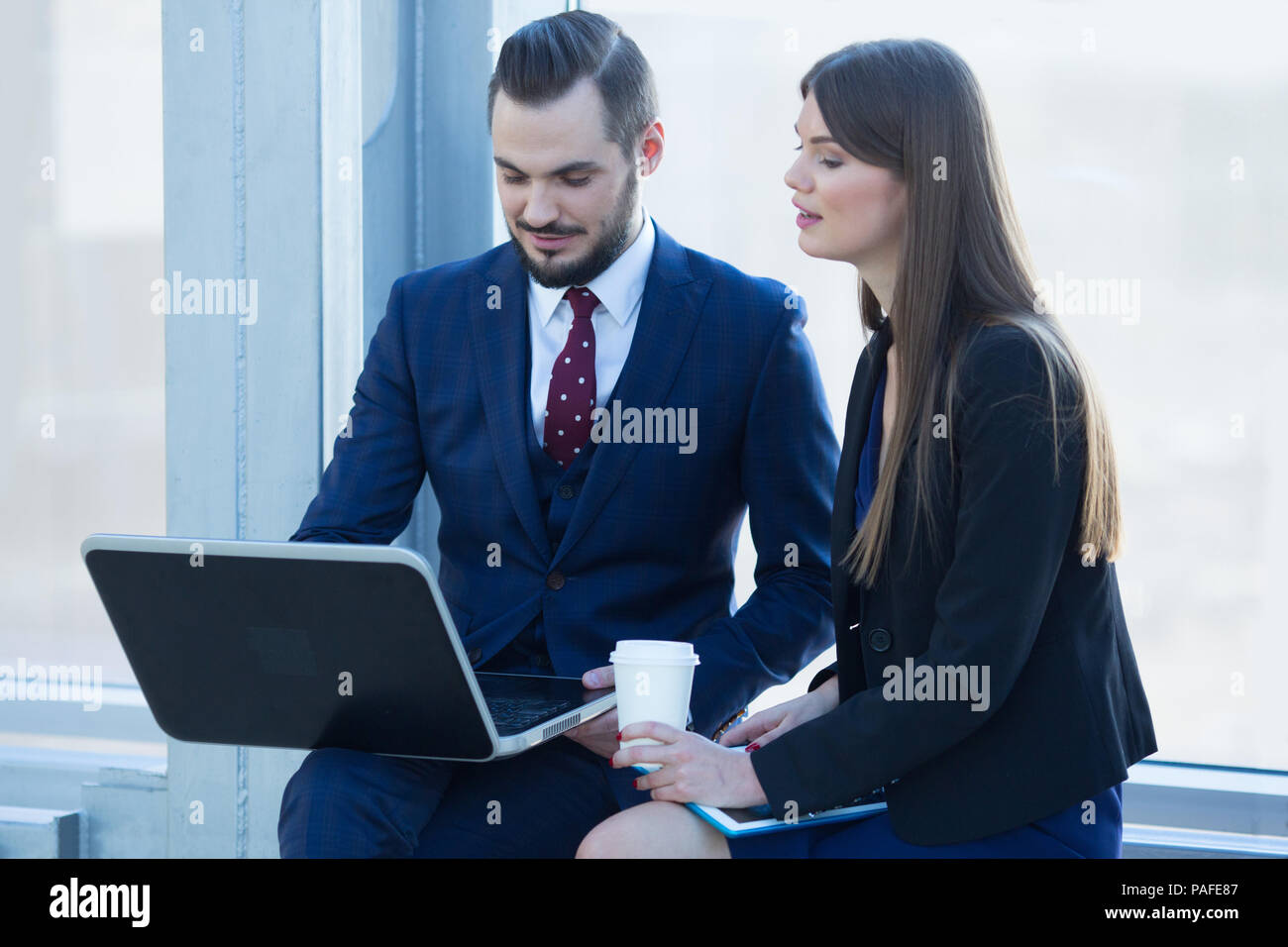 Business people having a break, sitting with laptop and smiling Stock ...