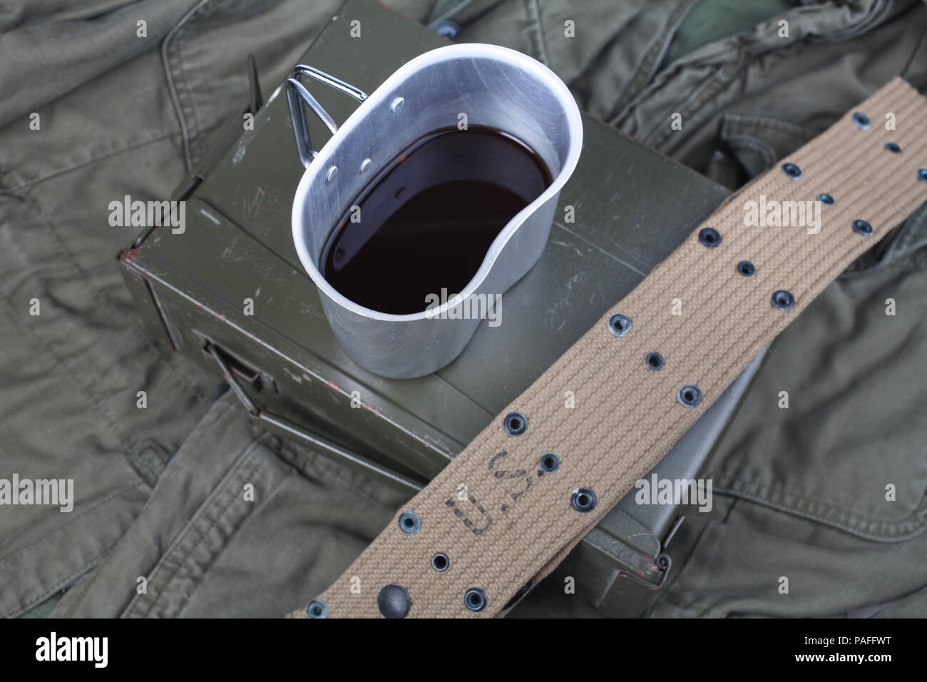 a cup of coffee with ww2 period us army military equipment on green ...