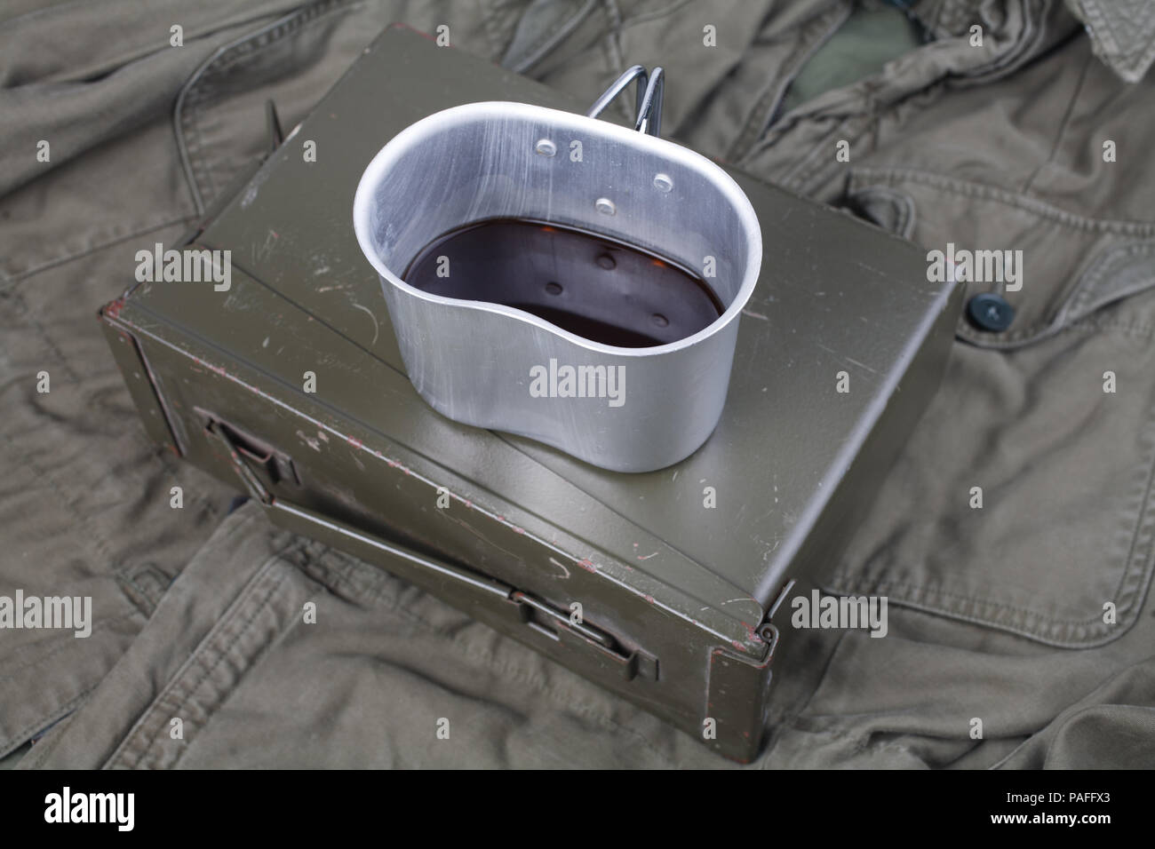 a cup of coffee with ww2 period us army military equipment on green ...