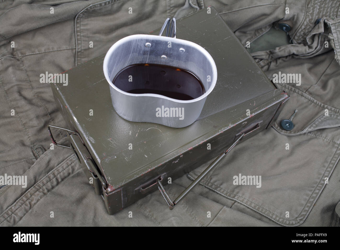 a cup of coffee with ww2 period us army military equipment on green ...
