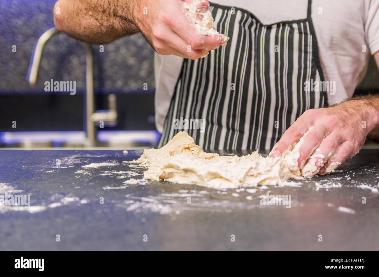 Man preparing pizza dough on black granite table Stock Photo - Alamy
