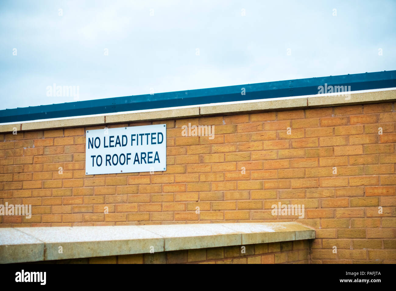 Signs on a building warning about no lead fitted to roof Stock Photo ...