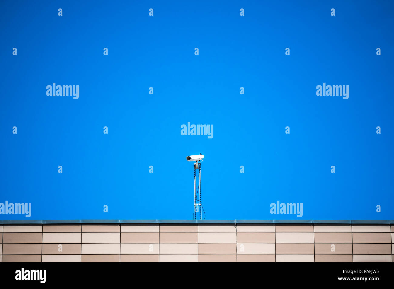 A CCTV security camera n=mounted on top of a new modern high rise ...