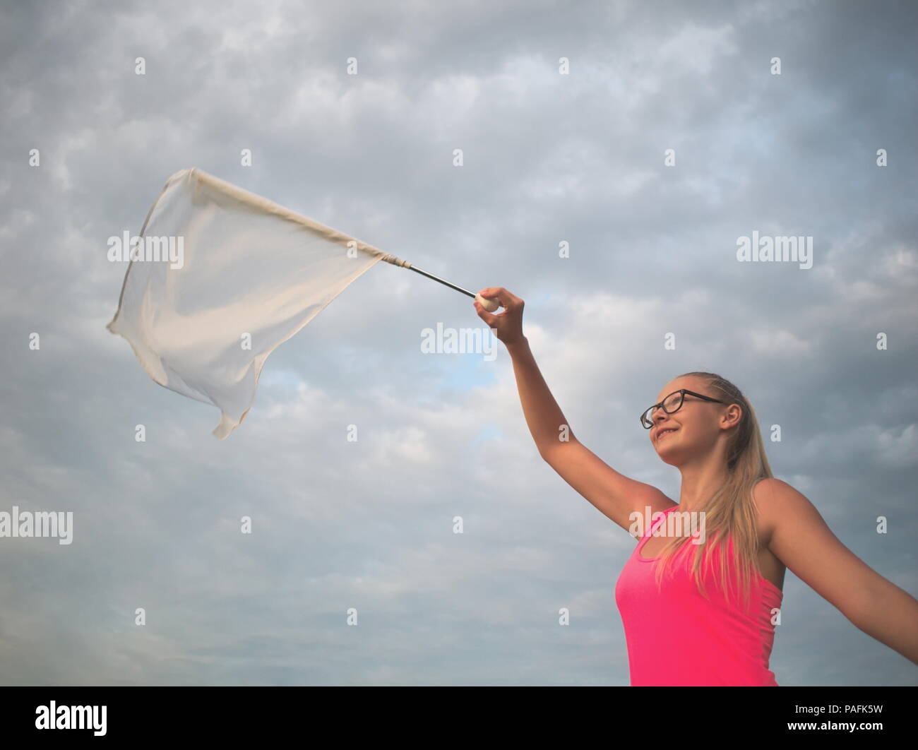 Bespectacled Blonde Teen Majorette Girl with White Flag Outdoors Stock ...