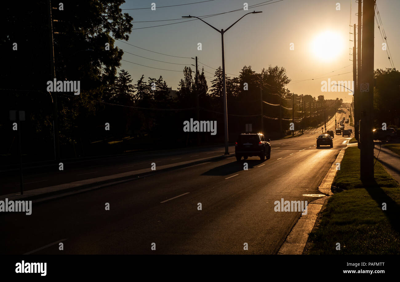 Colour horizontal image showing cars driving along long road towards ...