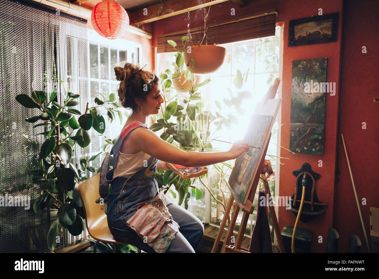 Indoor shot of professional female artist painting on canvas in studio ...