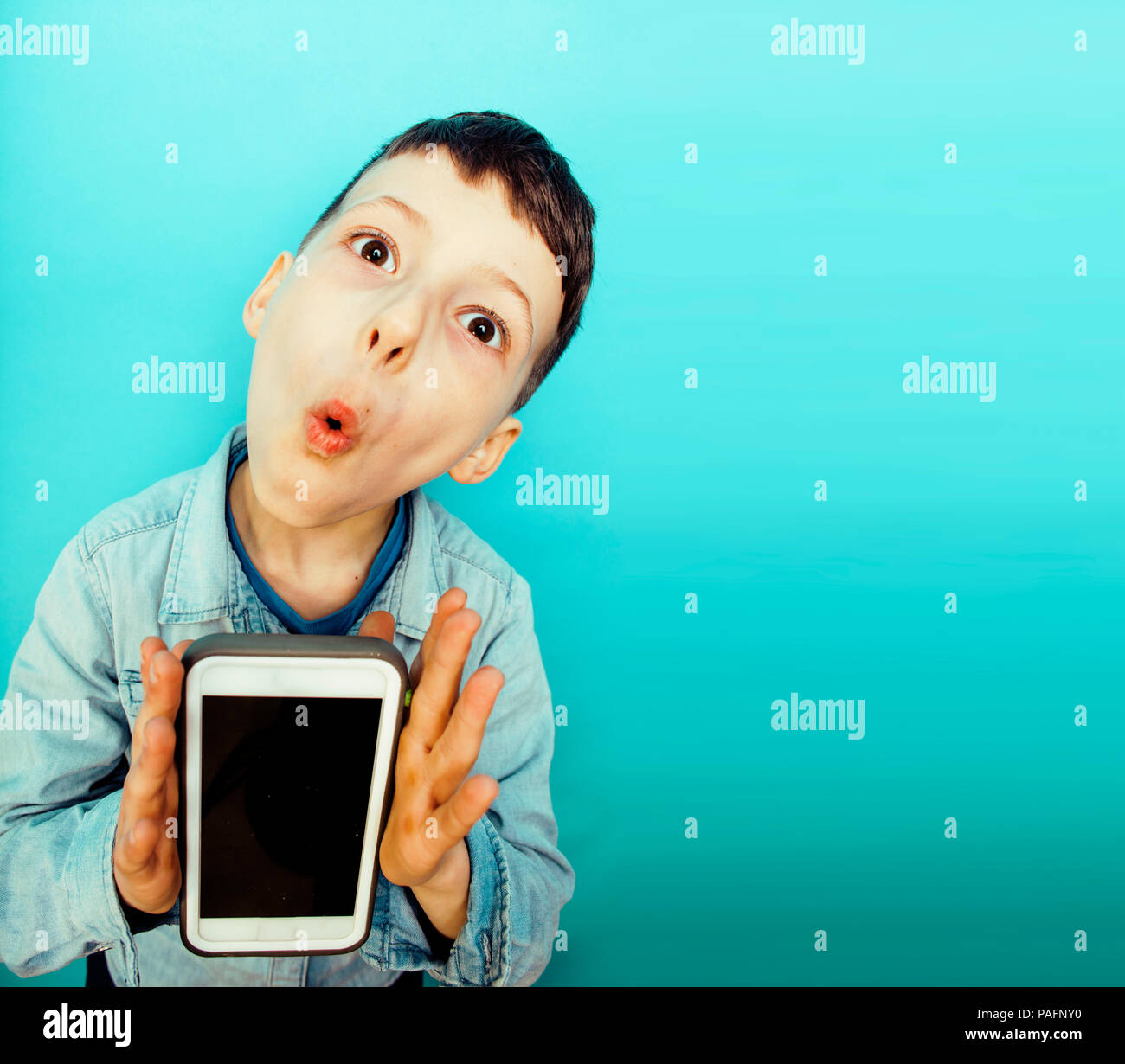 little cute boy posing emotional on blue background with smartph Stock ...