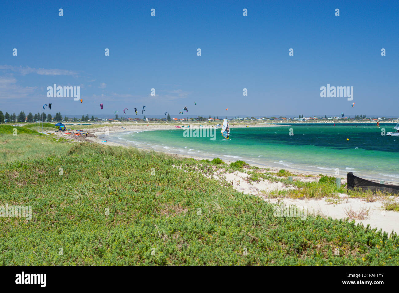 Sailboat and windsurfers on fine day with clear blue water at Safety ...