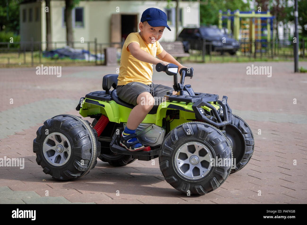Portrait of a happy child on an ATV. The boy drives a car in an ...