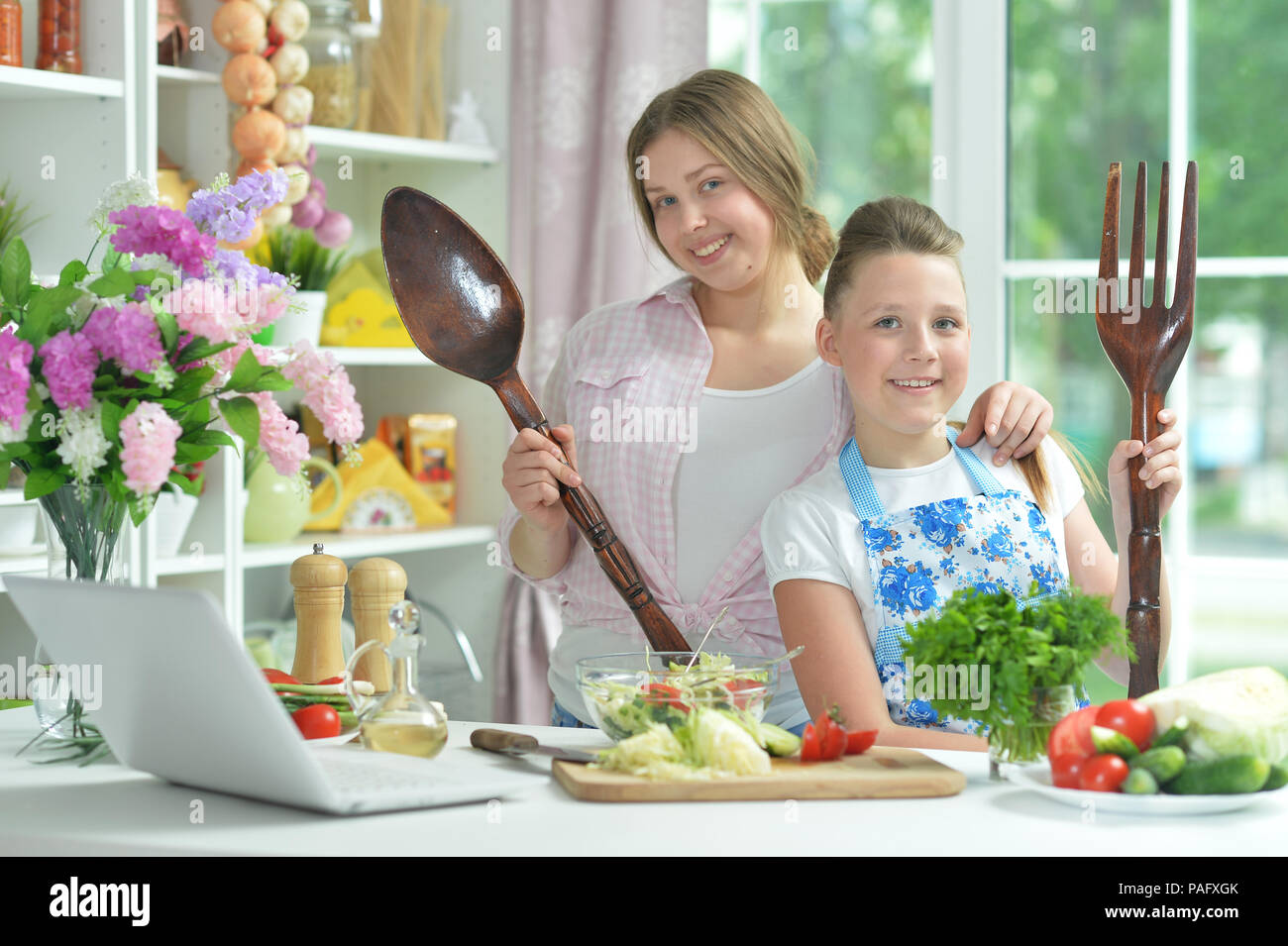 Two girls having fun while preparing fresh salad Stock Photo - Alamy