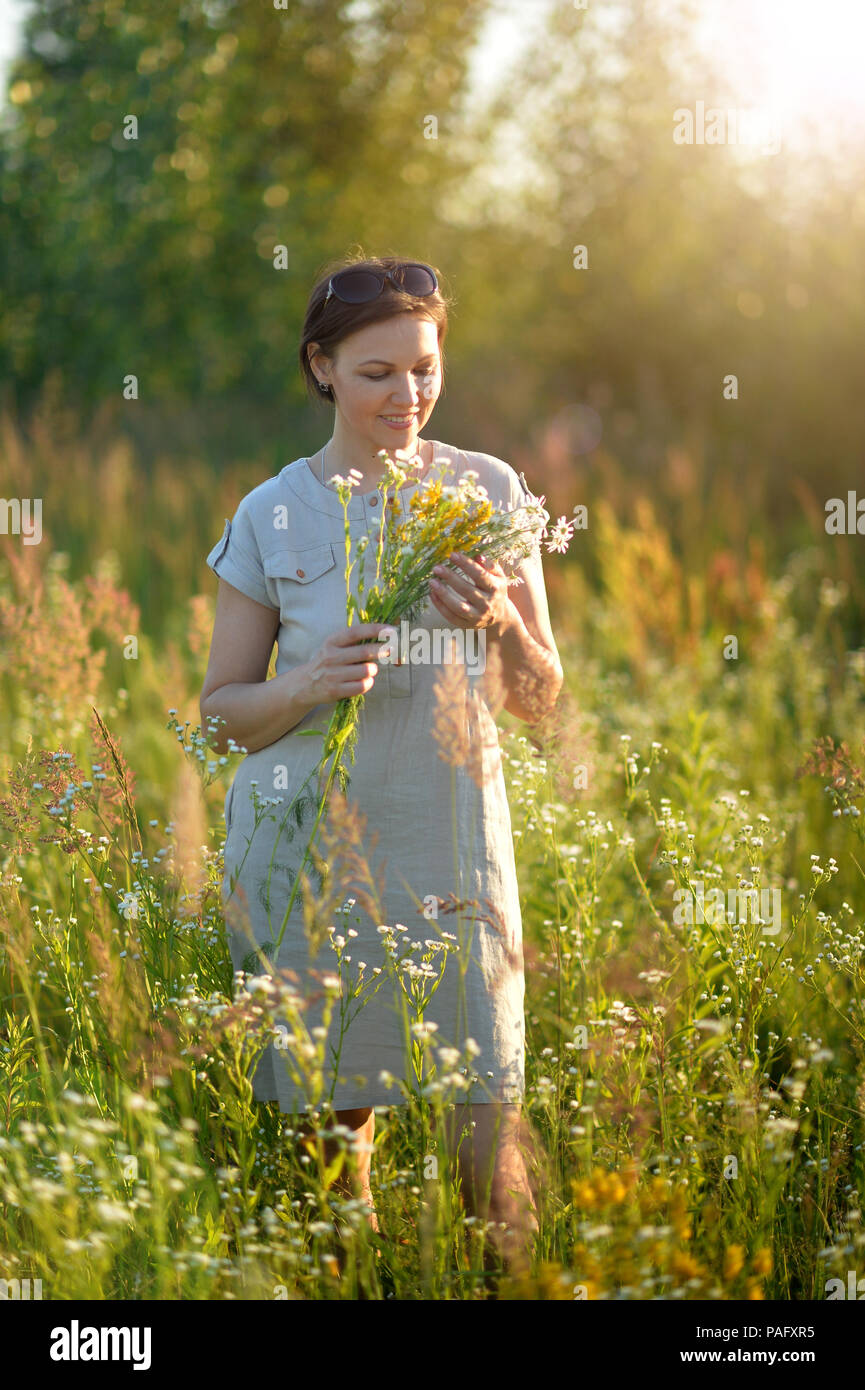 Beuatiful young woman holding wildflowers Stock Photo - Alamy