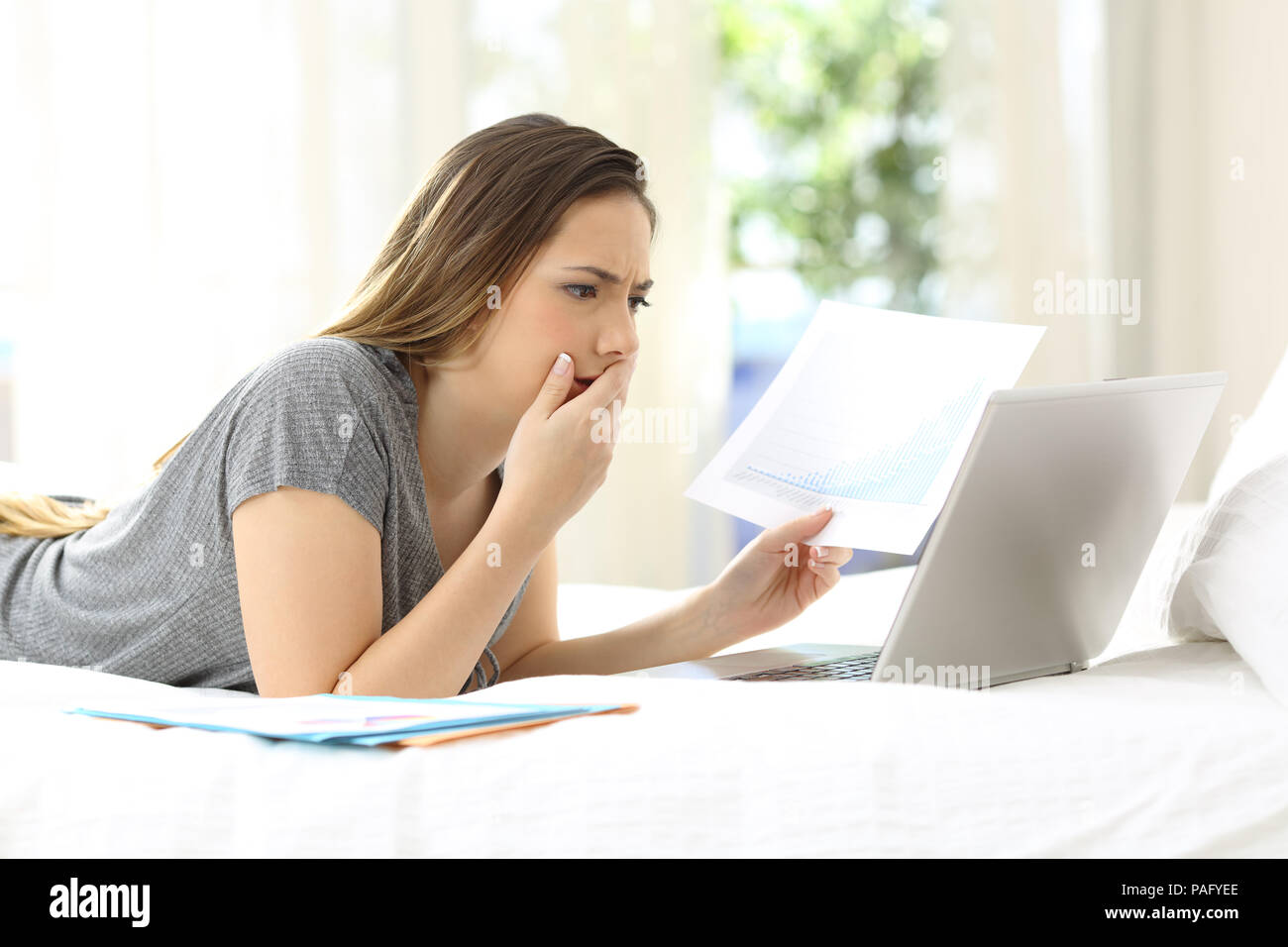 Worried self employed working comparing documents online at home Stock ...