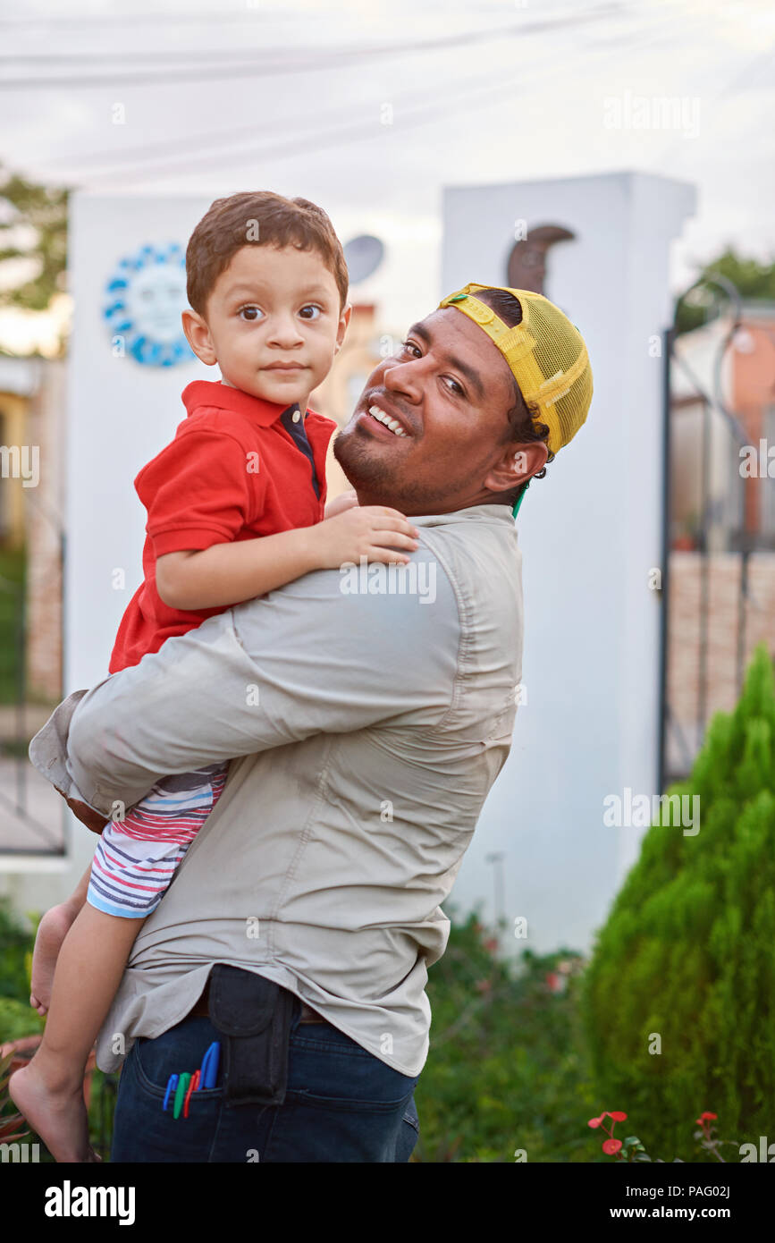 Happy latino father holding son after finish work day Stock Photo - Alamy